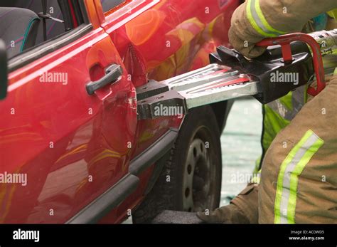 Fireman Using The Jaws Of Life To Gain Access To A Car Crash Victim