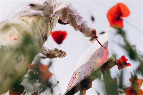 다운 증후군을 앓고있는 소년은 이젤 앞에 서서 들판에서 캔버스에 조심스럽게 그림을 그립니다 정신 건강에 대한 스톡 사진 및 기타 이미지 정신 건강 꽃 식물 예술가