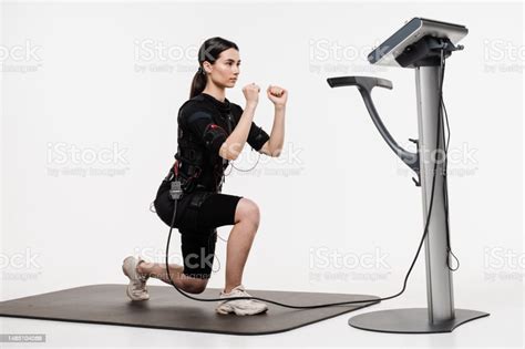 Ems 전기 근육 자극 슈트에서 스포츠 훈련 Ems 슈트를 입은 피트니스 소녀는 흰색 배경에 근육을 자극하기 위해 전기 충격을 사용하는 운동 스포츠 훈련을 하고 있다 18