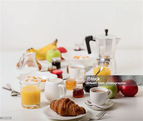 아침 식사 시간 크루아상 오렌지 주스 잼 및 꿀 크림 또는 우유와 커피 과일바나나 빨간색과 녹색 사과 사 워 크림 견과류 및 말린 살구와 함께 리 코타 건조 식품에 대한