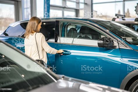 성인 여자는 자동차 딜러 앞에 있는 차에 실내에서 새 차의 문을 열고 있다 차에 대한 스톡 사진 및 기타 이미지 차 파란색