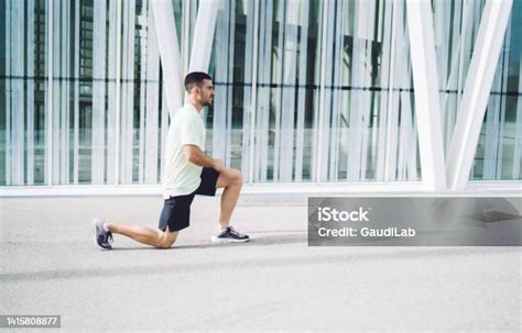 아침 운동 중 신체 레크리에이션을 즐기며 다리를 스트레칭하는 스쿼트를하는 결정적 인 남성 운동 선수 에너지를 얻기위한 온난화 운동을하는 근육질의 스포츠맨이 적합 훈련을