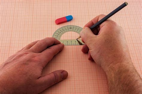 Premium Photo Man S Hand Draws A Diagram On A Sheet Of Graph Paper