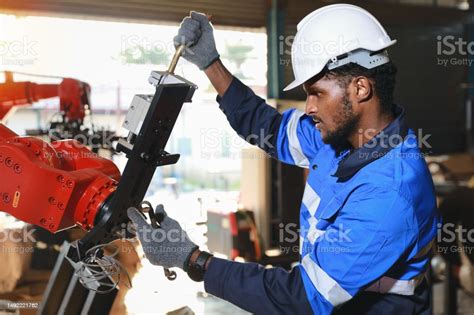 안전 작업복 유지 보수 분야의 전문 중공업 기술자 엔지니어이며 지능형 공장 자동차에서 로봇 암 기계의 일부를 확인합니다 산업 및 기술 지원 시스템 개념 25 29세에 대한