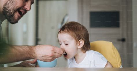 행복한 아버지 청년은 집에서 부엌에서 아기 소녀 어린 딸을 먹인다 사진 Unsplash의 건강한 라이프 스타일 이미지