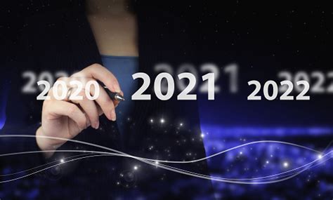 컨셉 은 새해 시작 2022 손 디지털 그래픽 펜을 들고 도시 어두운 흐린 배경에 디지털 홀로그램 2021 사인을 그리기 성공 새해 개념 비즈니스 관리영감 개념 12월에