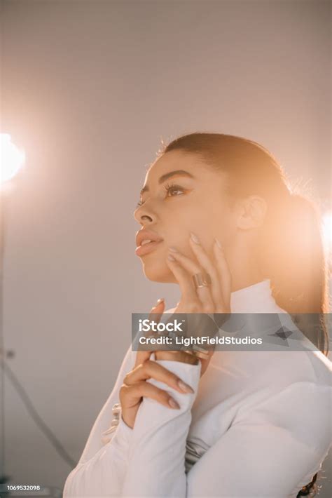 스포트 라이트와 함께 스튜디오에서 포즈를 취하는 아프리카계 미국인 여성 모델의 사이드 보기 사람들에 대한 스톡 사진 및 기타 이미지 사람들 사진 이미지 성인 전용