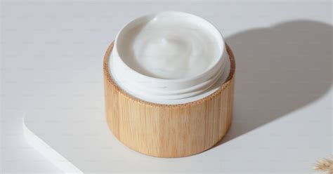 말린 꽃과 함께 흰색 연단에 천연 유기농 크림 보습제의 항아리 친환경 대나무 포장의 바이오 화장품 사진 Unsplash의 Jar 이미지