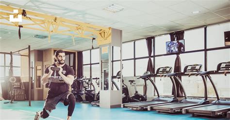 검은 탱크 탑과 파란색 데님 청바지를 입은 여자가 검은 가죽 벤치에 앉아 있다 사진 Unsplash의 무료 사람의 이미지