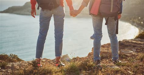 여성 여행자가 서로 팔짱을 끼고 등을 대고 서 있는 모습 물로 씻은 해안선이 그들 앞에 있습니다 사진 Unsplash의 손 이미지