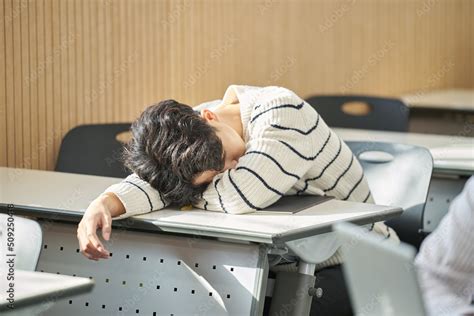 Foto de 아시아 대한민국 고등교육 강의실에서 책상에 엎드려 잠이든 대학생 아시아 젊은 남자 모델 do Stock Adobe Stock