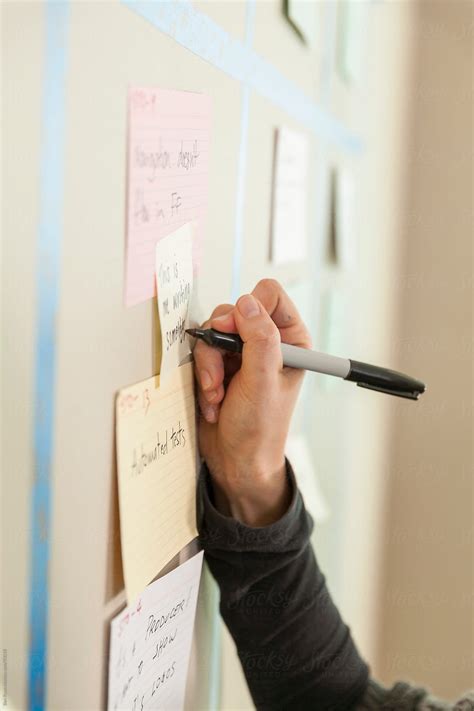 Agile Software Team Member Writing On The Iteration Card Wall By Agile Software Team Member Writing On The Iteration Card Wall By