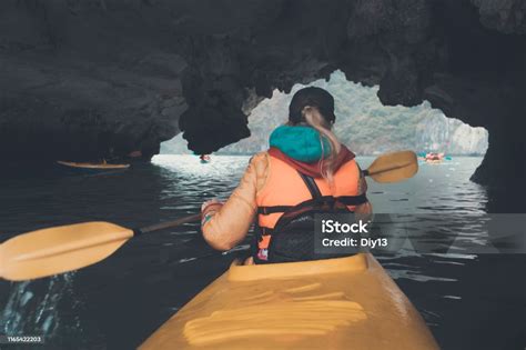 여자는 카약동굴을 탐험한다 동굴 안에 노란색 카약에 떠있는 여자 베트남 하 롱 베이 동굴에 대한 스톡 사진 및 기타 이미지 동굴 십대 카누 카누와 카약 Istock