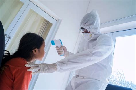 Premium Photo Doctor Checks A Girl Temperature With Thermometer