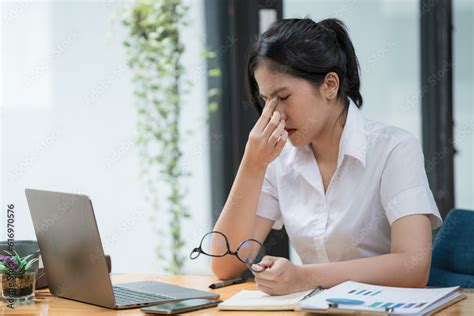 an asian businesswoman is serious at work causing headaches and