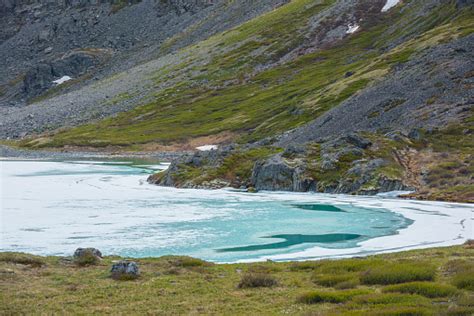 바위 사이 고산 호수에서 얼어 붙은 물과 아름다운 산악 풍경 얼음 산 호수의 자연 배경 냉동 고산 질감 얼음 수면의 자연적인 배경 얼어붙은 호수가 닫힙니다 0명에 대한 스톡