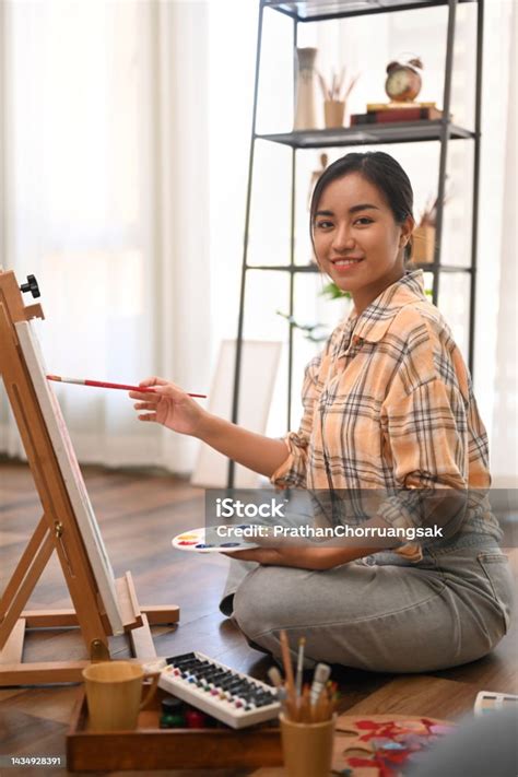 팔레트를 들고 있는 여성 예술가의 초상화와 아늑한 홈 스튜디오에서 유성 페인트로 캔버스에 그림을 그립니다 25 29세에 대한 스톡 사진 및 기타 이미지 Istock