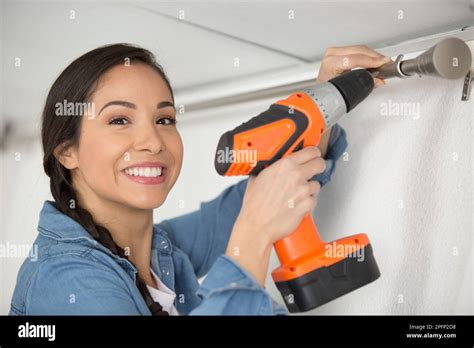 Woman Securing Curtain Rail Support Witha Cordless Drill Stock Photo Alamy