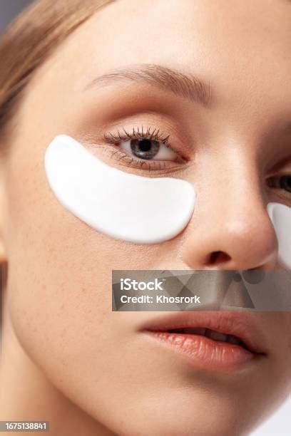 아름다운 여성 모델이 하이드로겔 패치 미용 루틴을 적용하는 얼굴을 돌보고 있다 불타는 듯한에 대한 스톡 사진 및 기타 이미지