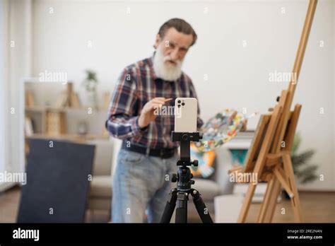Progressive Gentleman Of Mature Age Standing Confidently In Front Of Black Tripod And
