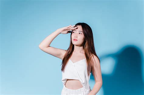 매력적인 아시아 뷰티 우먼은 파란색 배경에 자외선 차단 Uv 또는 자외선 차단제로 선크림과 컬러 스케일을 들고 있습니다 긴