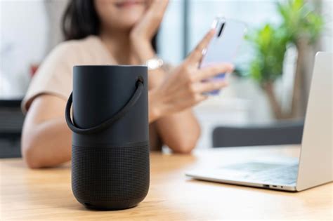 Premium Photo Closeup On Hand Using Phone Connecting Portable Speaker