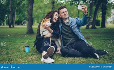 Handsome Young Man Is Taking Selfie With His Girlfriend Who Is Holding