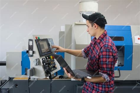 Premium Photo An Operator Of Cnc Is At Work Near The Panel Of Management A Machinetool With Laptop
