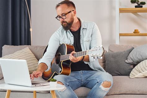 작곡 과정 캐주얼 한 옷을 입고 어쿠스틱 기타를 가진 남자는 실내에 있습니다 35 39세에 대한 스톡 사진 및 기타 이미지