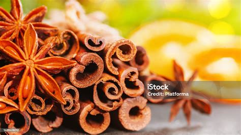 계피 스틱 스타 아니스 가을과 겨울 온난화 음료를 준비하기 위한 말린 레몬 화환과 Bokeh재료와 크리스마스 장식이 있는 크리스마스 트리의 배경 갈색에 대한 스톡 사진 및