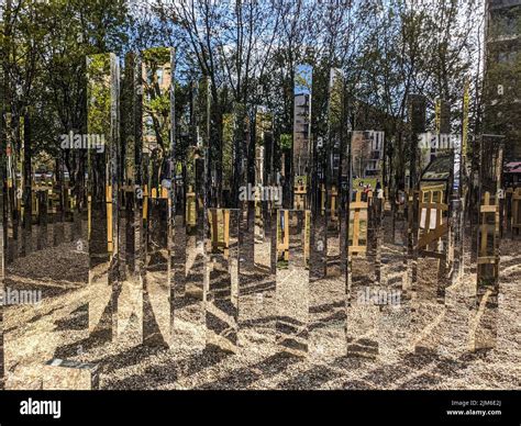 A Many Pillers Of A Mirror Material Reflecting The Park Around Them