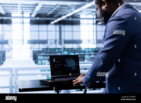 Computer Scientist In Data Center Using Laptop To Visualize Artificial