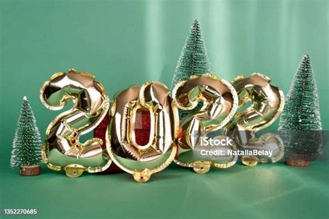 2022 년 황금 풍선 민트 색상의 배경에 고립 된 미니어처 크리스마스 트리 헬륨 풍선 금 호일 번호 2022년 새해 복 많이 받으기 파티 축하의 장식 0에 대한 스톡 사진