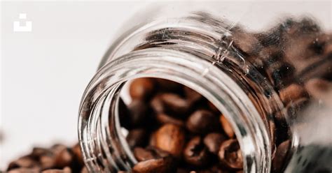 커피 원두 더미 위에 커피 원두로 채워진 유리병 사진 Unsplash의 무료 음료 이미지