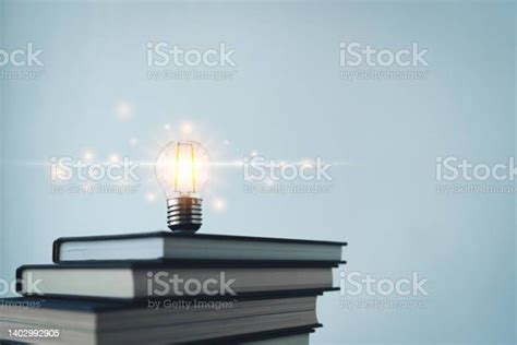 책이나 교과서가있는 빛나는 전구 또는 밝은 램프 학생 또는 사업가를위한 기술 향상 집에서 온라인으로 공부하고 훈련 과정 사업