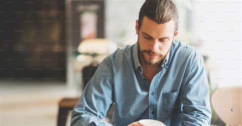 파란색 셔츠를 입은 수염 난 남성 프리랜서가 커피숍에서 책을 읽고 있다 사진 Unsplash의 책 이미지