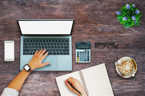 한 남자가 빈티지 나무 테이블에 노트북 컴퓨터를 사용하여 일하고 있습니다 키보드를 입력하는 손입니다 맨 위 보기입니다 계산기에 대한 스톡 사진 및 기타 이미지 Istock