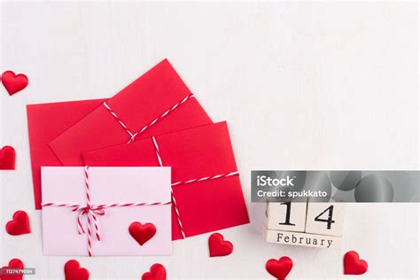 발렌타인 하루와 사랑 개념입니다 빨간 하트와 레드 핑크 편지 커버와 흰색 나무 바탕에 나무 블록에 2 월 14 일 텍스트 2월에