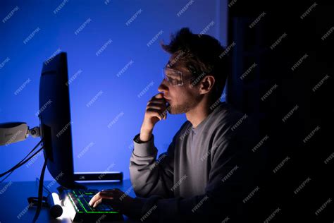 Premium Photo A Focused Male Developer Works On Programming Code On His Computer Screen In A