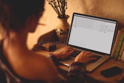 Back View Of Caucasian Female Programmer Siting At Desk Using Laptop