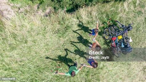 야외에서 자전거를 타는 가족 활동적인 부모와 자전거 타기 위에서 아름다운 강 근처에서 휴식을 취하는 아이들과 함께 행복한 가족의 공중 보기 스포츠 및 피트니스 개념 양