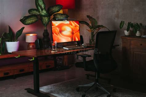 Modern Office Desk With A Computer Monitor And A Decorative Lamp With Vibrant Red Lights Stock
