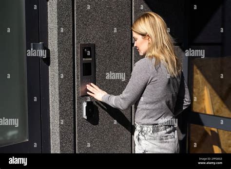 Woman Using Intercom At Building Entrance Stock Photo Alamy