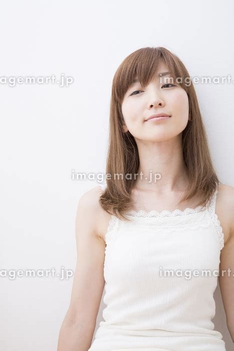 壁にもたれる女性の写真素材 [24001367] イメージマート