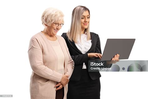 노트북 컴퓨터를 들고 노인 여성과 함께 서있는 사업가 25 29세에 대한 스톡 사진 및 기타 이미지 25 29세 2명 70 79세 Istock