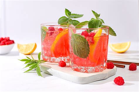 시원한 홈메이드 레모네이드 칵테일 햇볕이 잘 드는 테이블에 민트 라즈베리 과일을 곁들인 모히토 상쾌한 여름 음료 레시피 디톡스 다이어트 및 체중 감량 개념 레스토랑 메뉴 0