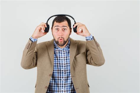 Free Photo Young Man Taking Off Headphones In Shirt Jacket And