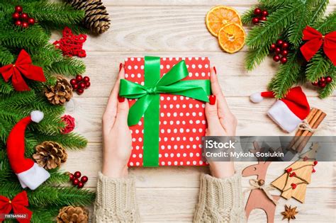 축제 나무 배경에 그녀의 손에 선물 상자를 들고 여자의 상단보기 전나무 나무와 크리스마스 장식 새해 시간 컨셉 Diy에 대한