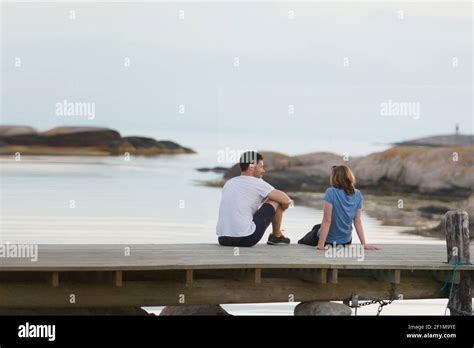 Couple Sitting On Jetty Stock Photo Alamy