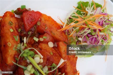 매운 토마토 소스에 담긴 감자 웨지와 잘게 썬 야채 당근 양상추 빨간색과 흰색 양배추를 화이트 플레이트에 곁들인 사이드 샐러드를 뿌린 다진 파를 클로즈업 한 이미지 높은